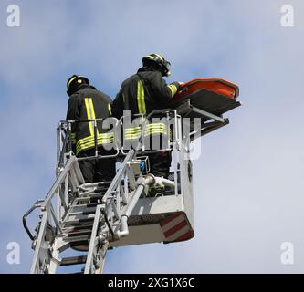 Firefighters on board an aerial platform crane with suspended stretcher ...