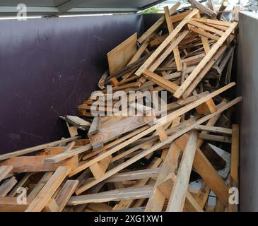 wooden pieces planks and broken pallets in the wood recycling container ...