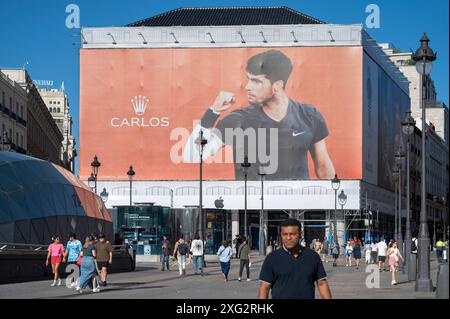 Pedestrians walk past a large commercial advertisement billboard from ...