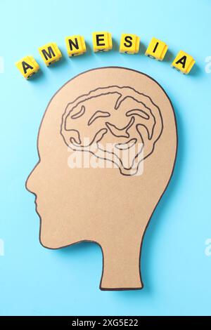 Amnesia. Human head cutout with drawing of brain and magnifying glass ...