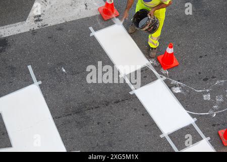 Road painter worker working on zebra crossing of a city street Stock ...