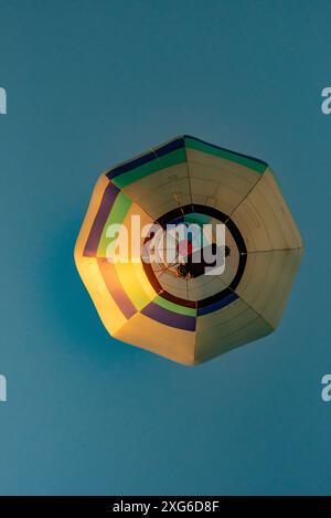 Shot from below, a single octagonal hot air balloon climbs at the 2024 ...