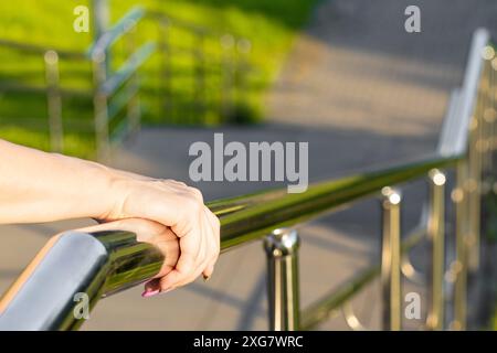woman's hand holding onto the metal staircase railing. a man goes down ...