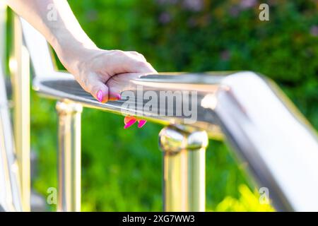 woman's hand holding onto the metal staircase railing. a man goes down ...