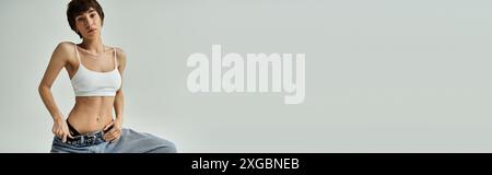 A fit woman strikes a confident pose in the gym after an intense workout, showcasing her ...