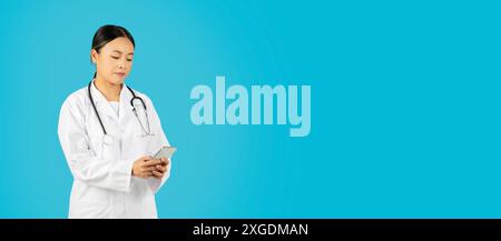 Asian female doctor using smartphone at medical office desk with ...