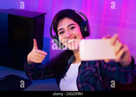 Gamer taking a selfie in gaming room playing online streaming games ...