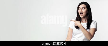 Portrait, brand and smiling woman pointing finger isolated against a ...