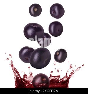 Acai berries falling into juice on white background Stock Photo - Alamy