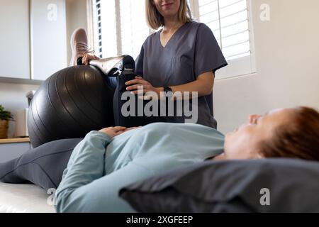 Physical therapist assisting patient with prosthetic leg using exercise ...