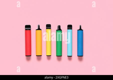 Different electronic cigarettes on pink background Stock Photo - Alamy