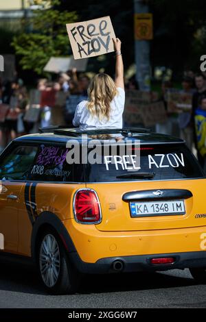 Ukrainian activists ride in a car with a flag of Azov brigade and sign ...