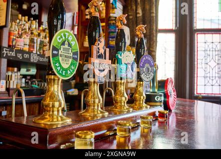 Hand pull beer pumps on the bar of the Black Horse pub in Preston city ...