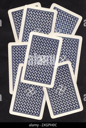 A hand of vintage playing card backs with the three of spades revealed ...