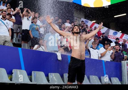 A fan bathes in rainwater falling from the stadium roof before the UEFA ...