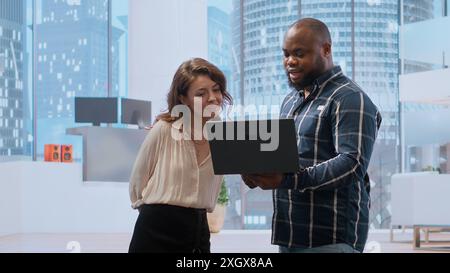 Realtor broker showing the architectural blueprints on laptop to the ...