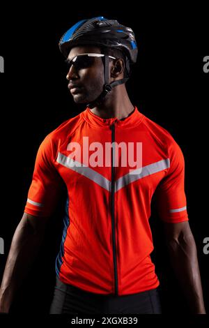 African American cyclist poses confidently on a black background, with ...