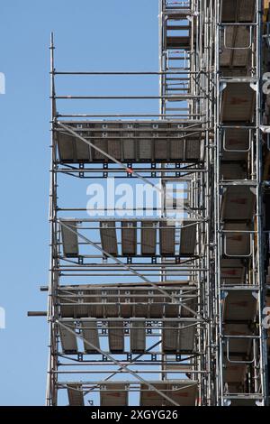 Scaffolded high-rise residential building with balconies and satellite ...
