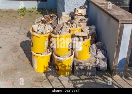 Yellow buckets filled with building rubble, Germany Stock Photo - Alamy