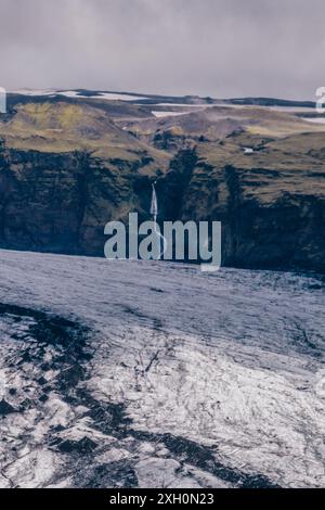 Aerial view of glacial ice cascading down rugged mountain terrain, a ...