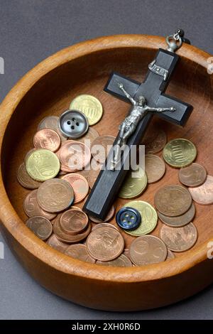 Crucifix with coins and buttons in a wooden bowl, church and money ...