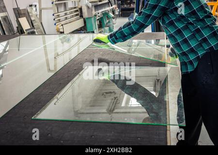 The glazier lifts the glass panes. Glass factory Stock Photo - Alamy