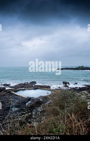 The large shallow historic tidal pool on the rocky shore in Mousehole ...