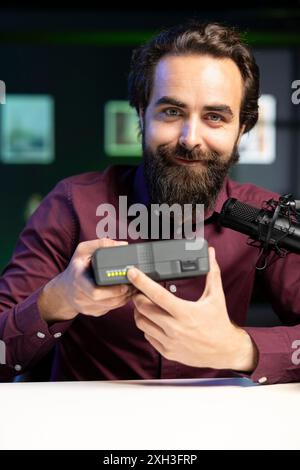 Tech expert presenting V mount battery, filming technology review using ...