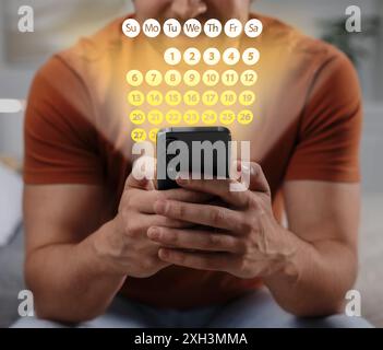 Timetable. Man making schedule using calendar and sticky note at table ...