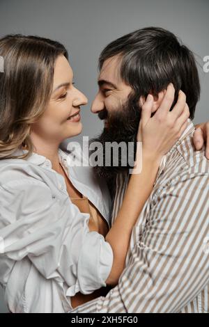 A couple in sophisticated attire gaze lovingly at each other, creating ...