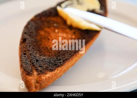 Burnt toast whole wheat and knife spreading butter Stock Photo - Alamy