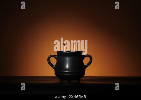 Mysterious black cauldron with witch legs protruding, On pumpkin orange ...