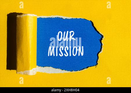 Our mission message written on ripped yellow paper with green background. Conceptual our mission ...