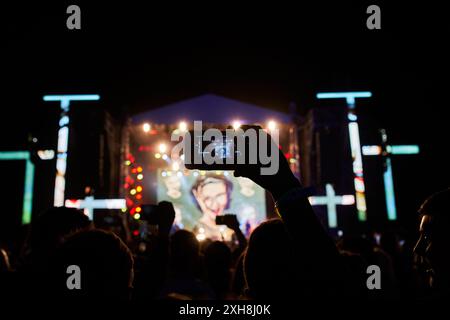 Festival goer records the concert with a smartphone on the third day of ...