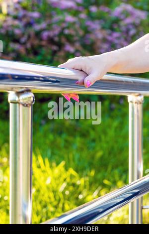 woman's hand holding onto the metal staircase railing. metal stair ...