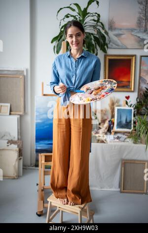 Artist palette with oil paints and brushes on a wooden background ...