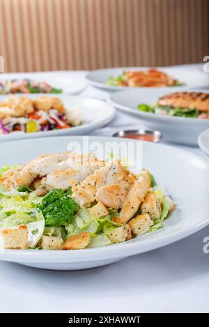 A view of several salad plates, featuring chicken Caesar and antipasto ...
