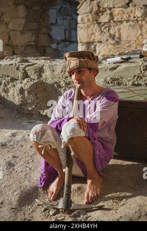 A mercenary of Arab appearance sleeps sitting next to a chest with his ...
