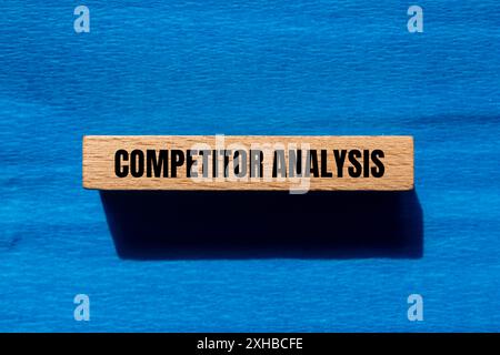 Competitor analysis message written on wooden block with blue ...