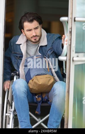 a disabled man on wheelchair exiting a building Stock Photo - Alamy