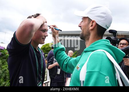 Novak Djokovic signs fans forehead as he makes his way to training on ...