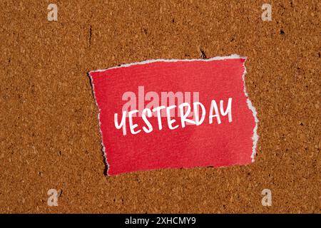Yesterday word written on ripped white paper piece with brown ...