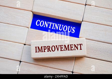 Top view of continuous improvement text on blue wooden blocks with ...