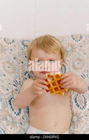 Toddler eating waffle Stock Photo - Alamy