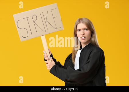 Protesting female judge holding placard with text STRIKE on yellow ...