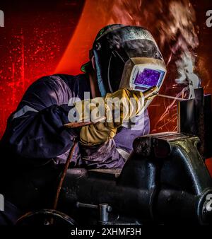 Welding in heavy machine shop Stock Photo - Alamy