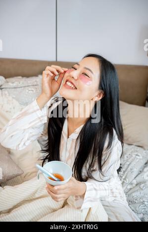 Asian woman applying eye mask patches for skincare beauty treatment at ...
