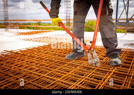 Worker is standing on pile of rusty rectangle steel, reinforcement for ...