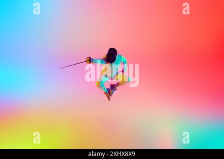 Fencer in uniform and mask in impressive jump, holding rapier forward ...