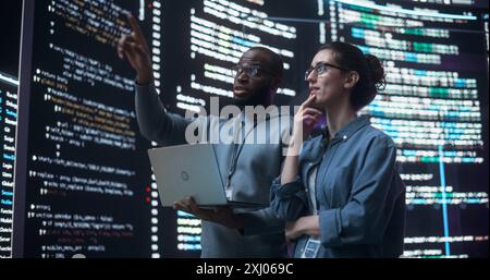 Software developers discussing and fixing bugs in programming code Stock Photo - Alamy